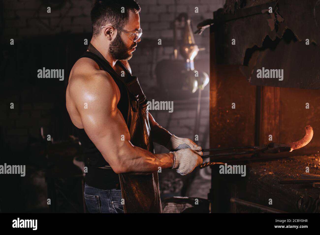 male blacksmith forging in his workshop, make iron products for ...