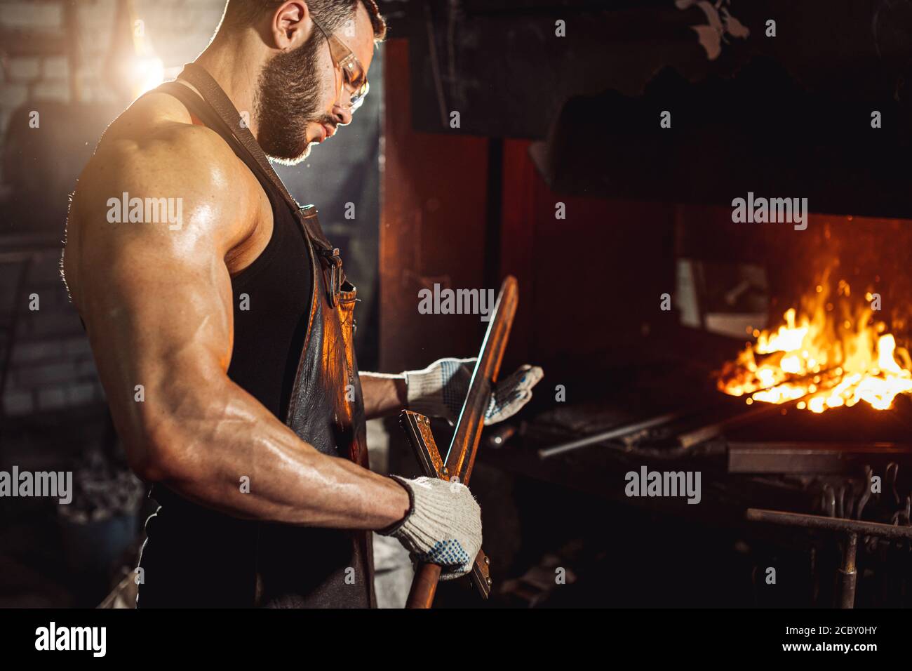 male blacksmith forging in his workshop, make iron products for ...