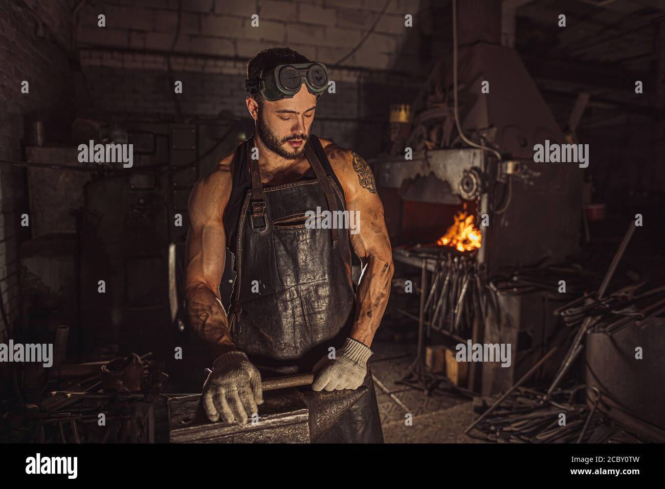 confident forger in leather uniform isolated in workshop. special ...