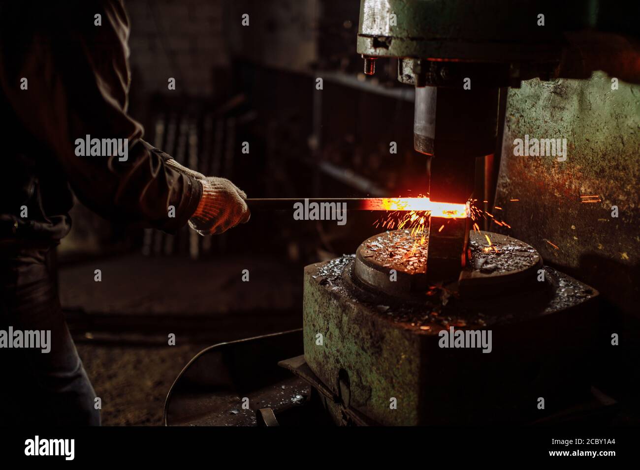 portrait of young male metalworker near furnace, young muscular in good ...