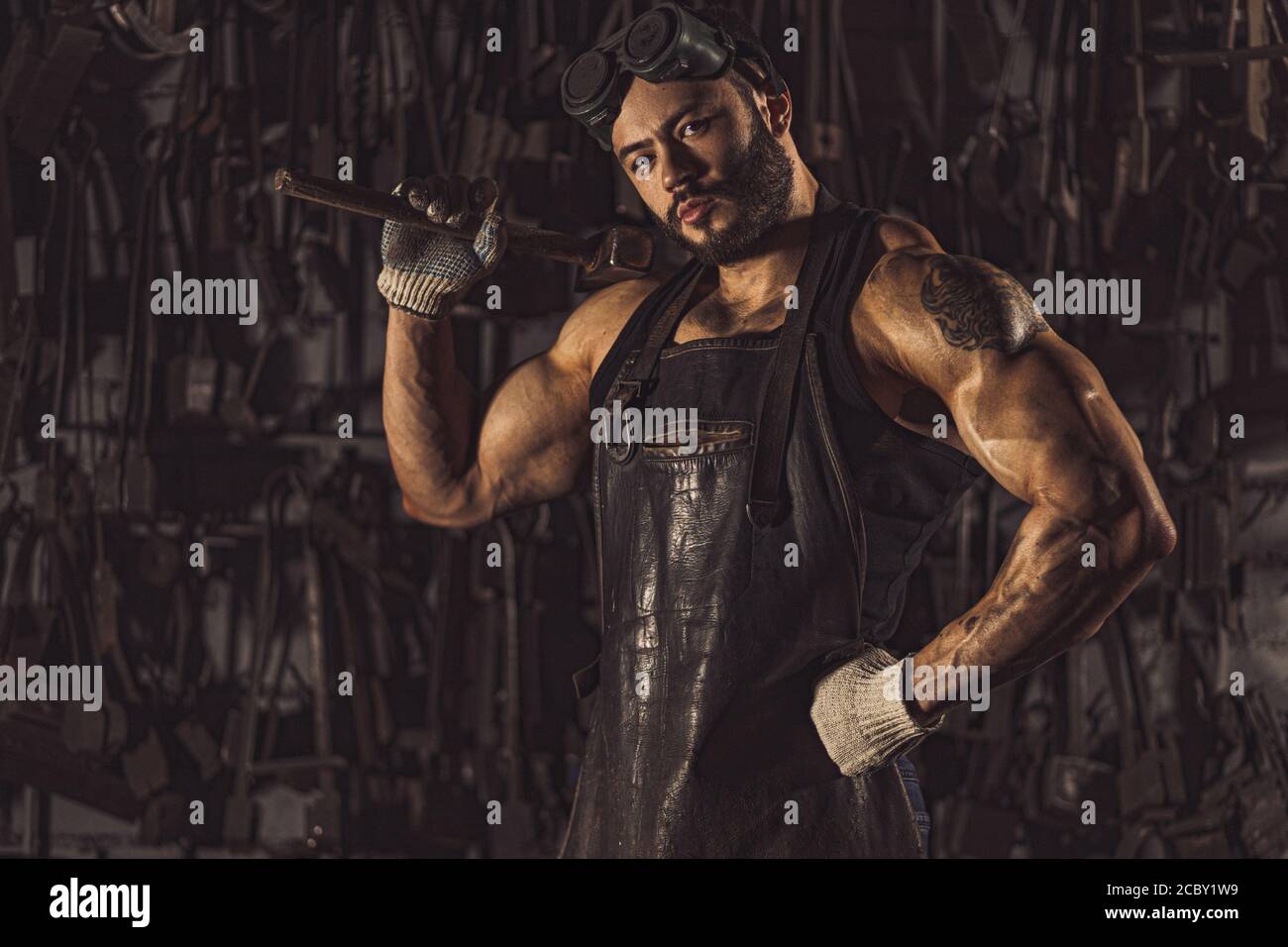 confident forger in leather uniform isolated in workshop. special ...