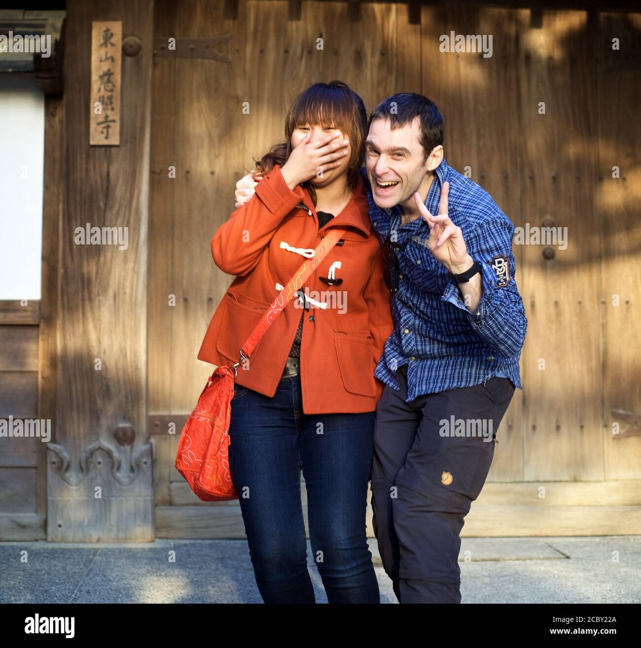 Japanese girl and occidental tourist making the V sign (hand gesture ...
