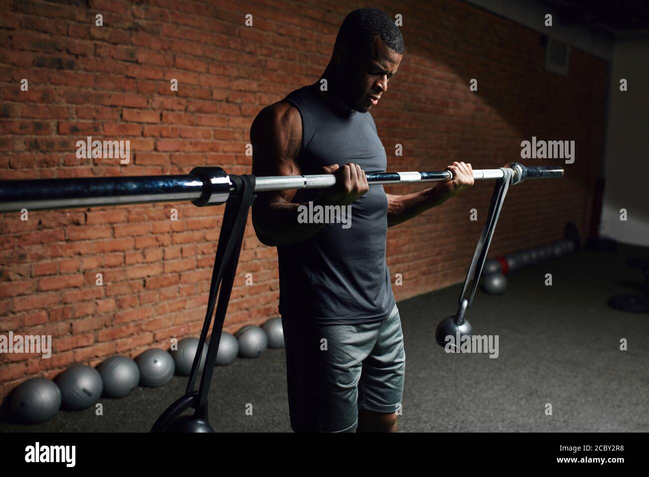 African man lifting a bar with weights in gym. Active People Sport ...