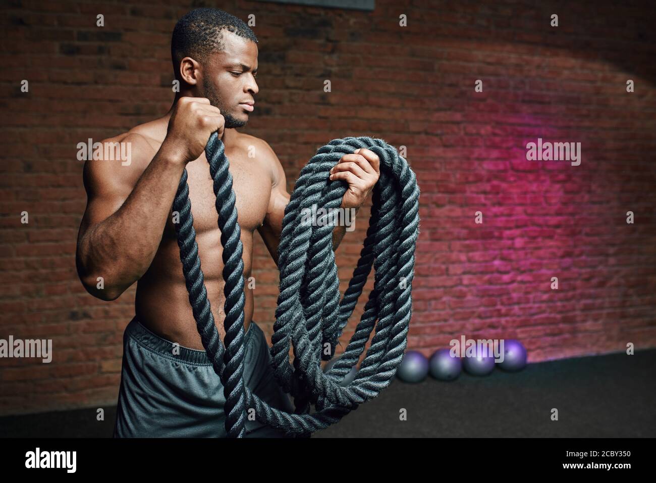 African cross fit coach stands with battle ropes proves that dynamic ...