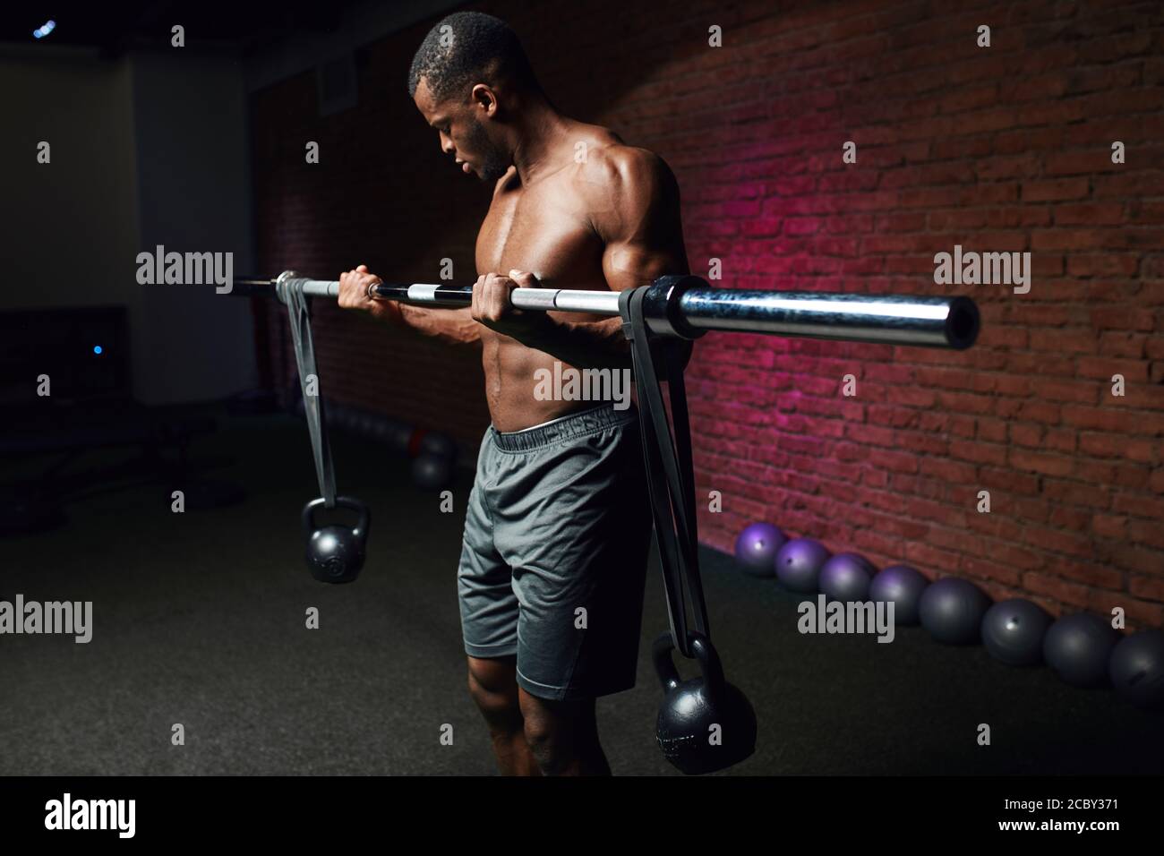 African man lifting a bar with weights in gym. Active People Sport ...