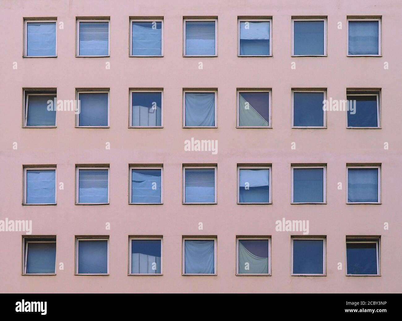 Modern pink facade with many square windows Stock Photo - Alamy
