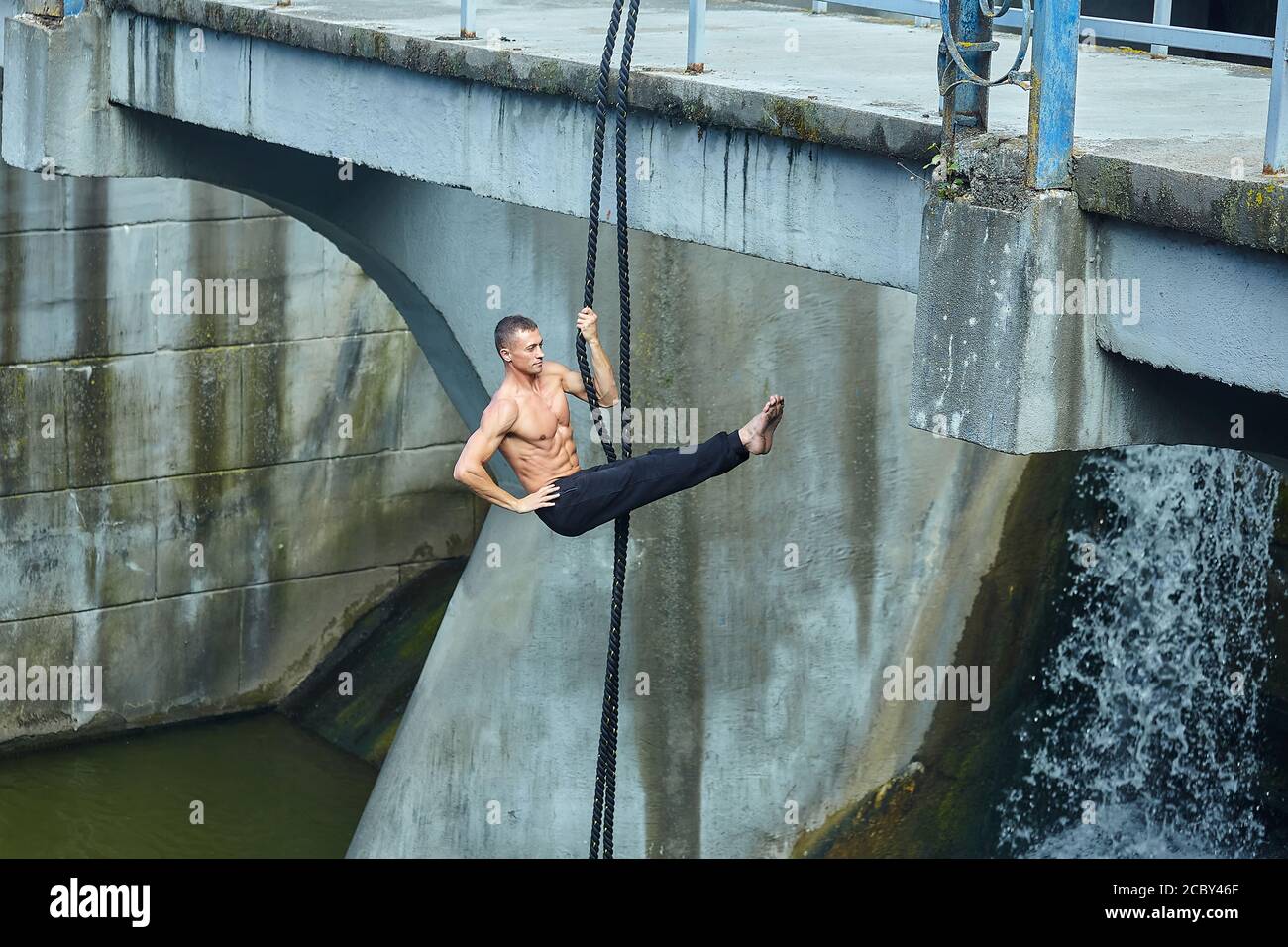 an athletic person performs dangerous exercises on a gymnastic rope. in ...