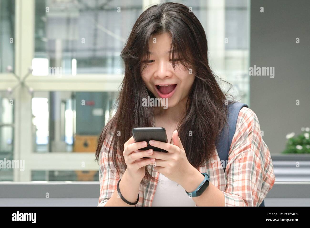 Asian woman react with joy by smiling happily while looking at her ...