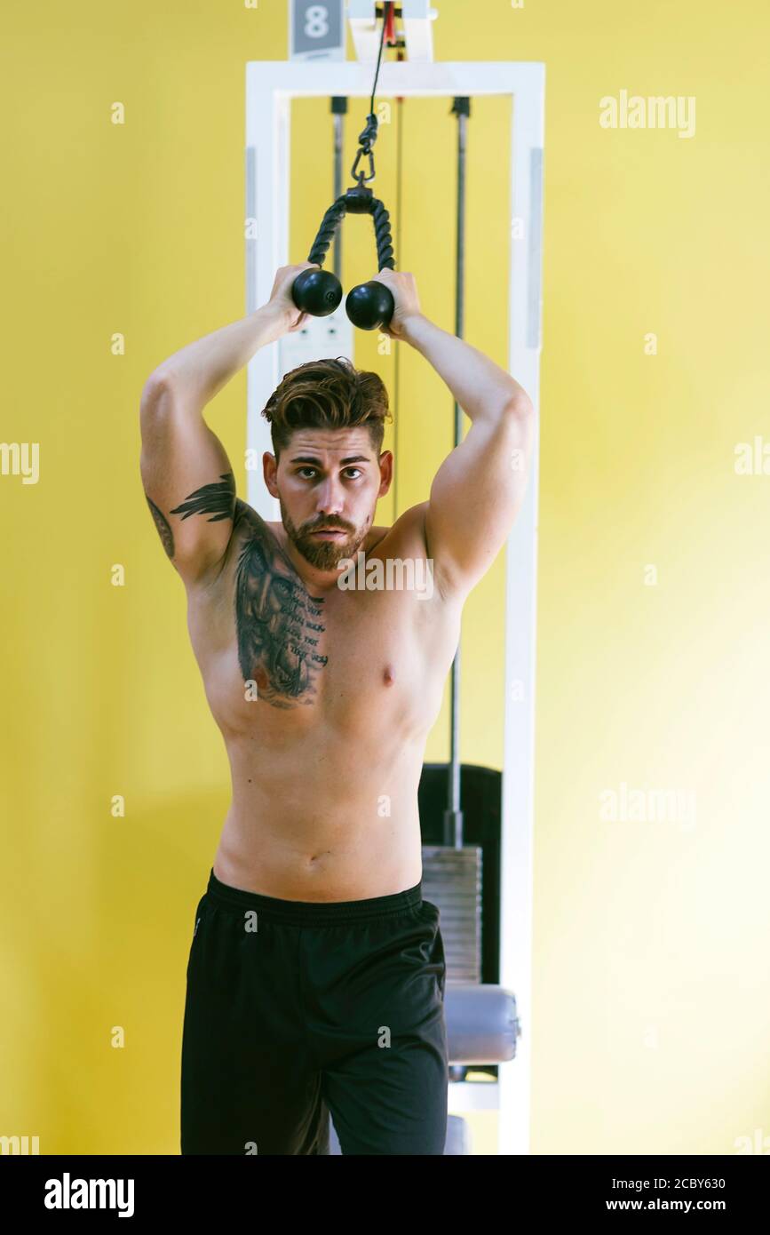 Fit man on lat pull down machine at the health club. Work out on Pull ...