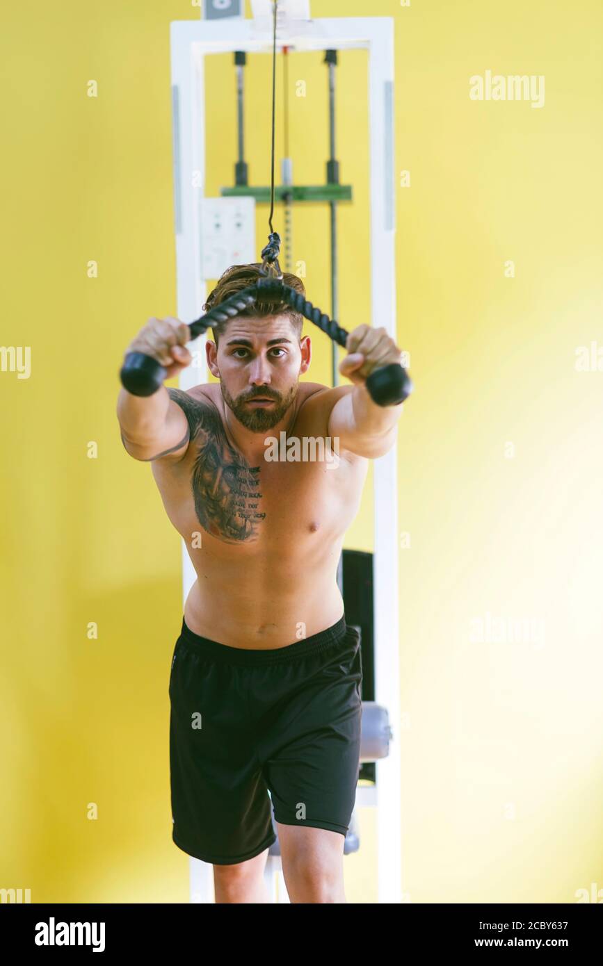 Fit man on lat pull down machine at the health club. Work out on Pull ...