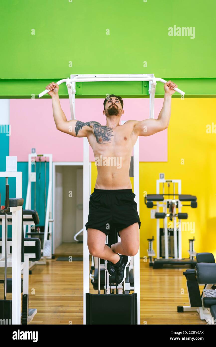 Muscular man workout doing pull ups on bar in gym,Man working out in a ...
