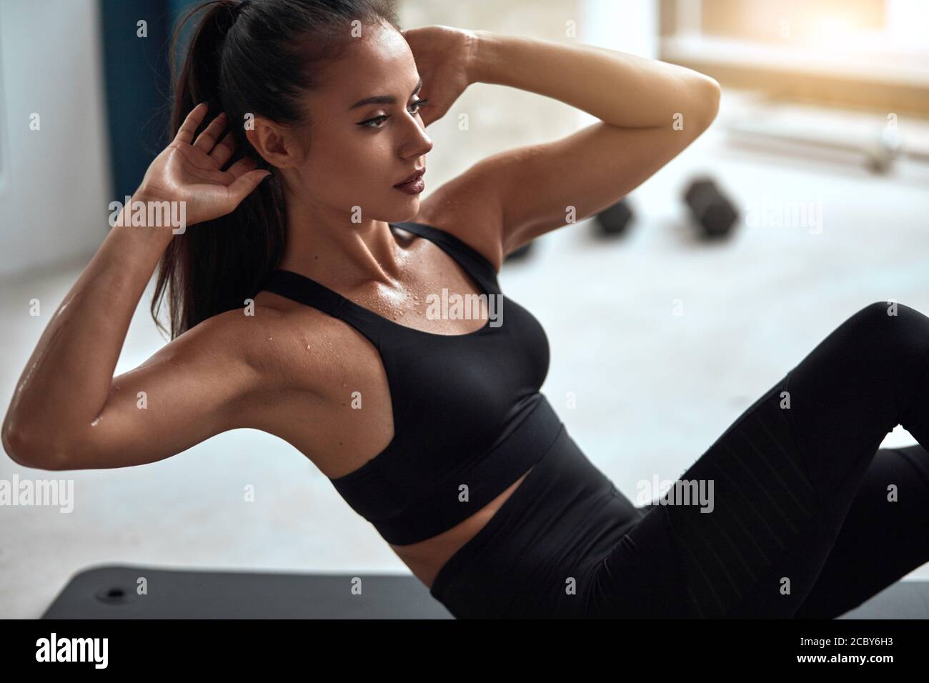 Attractive fit female pump press in gym. Fitness girl in black ...