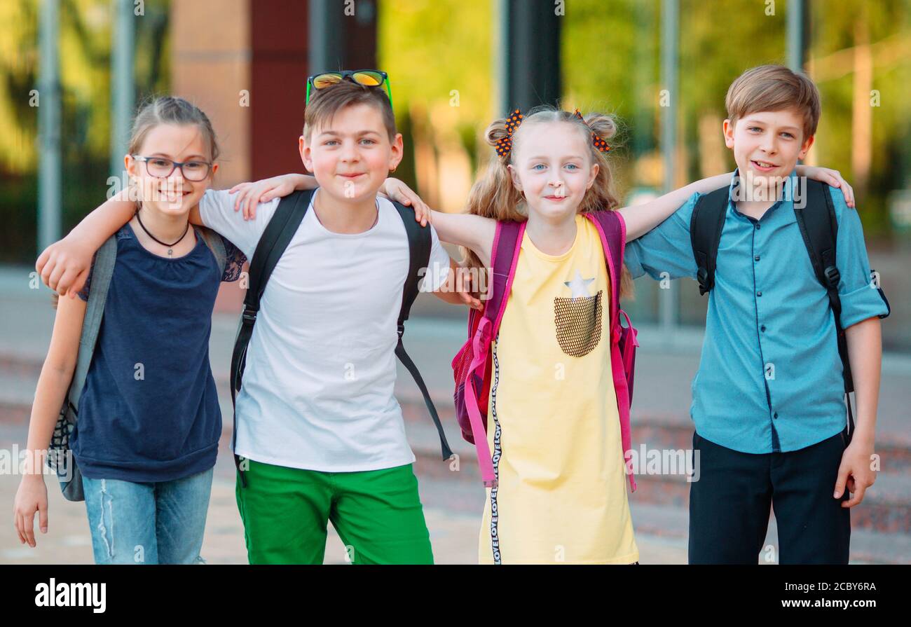 Children's friendship. Four little school students, two boys and two ...