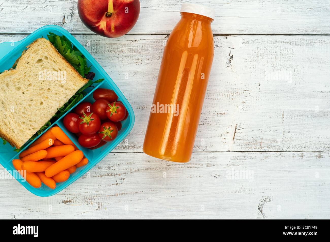 School lunch - plastic box with sandwich, tomatoes, carrots in sections ...
