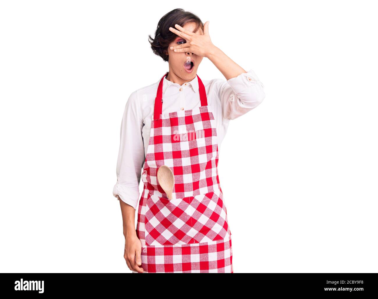 Beautiful young woman with short hair wearing professional cook apron ...