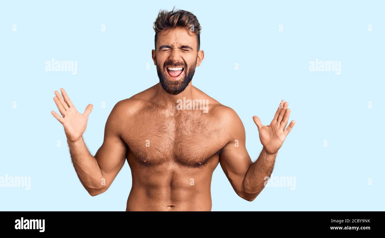 Young hispanic man wearing swimwear shirtless celebrating mad and crazy ...