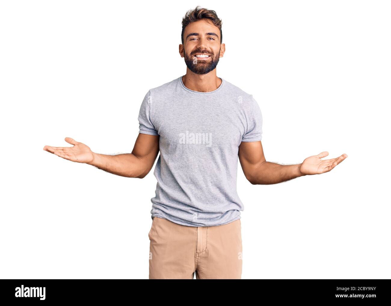 Young hispanic man wearing casual clothes smiling showing both hands ...