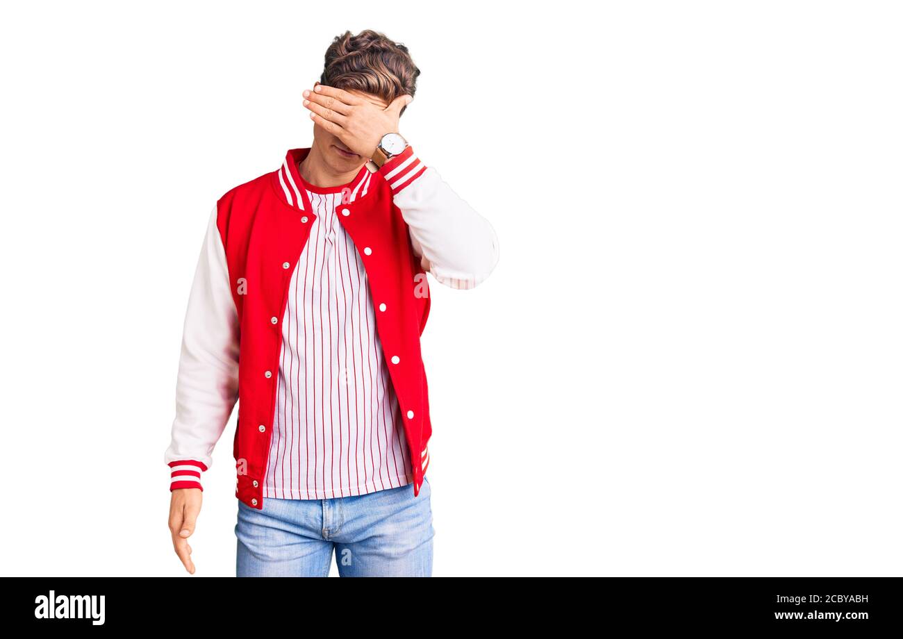 Young handsome man wearing baseball uniform covering eyes with hand ...