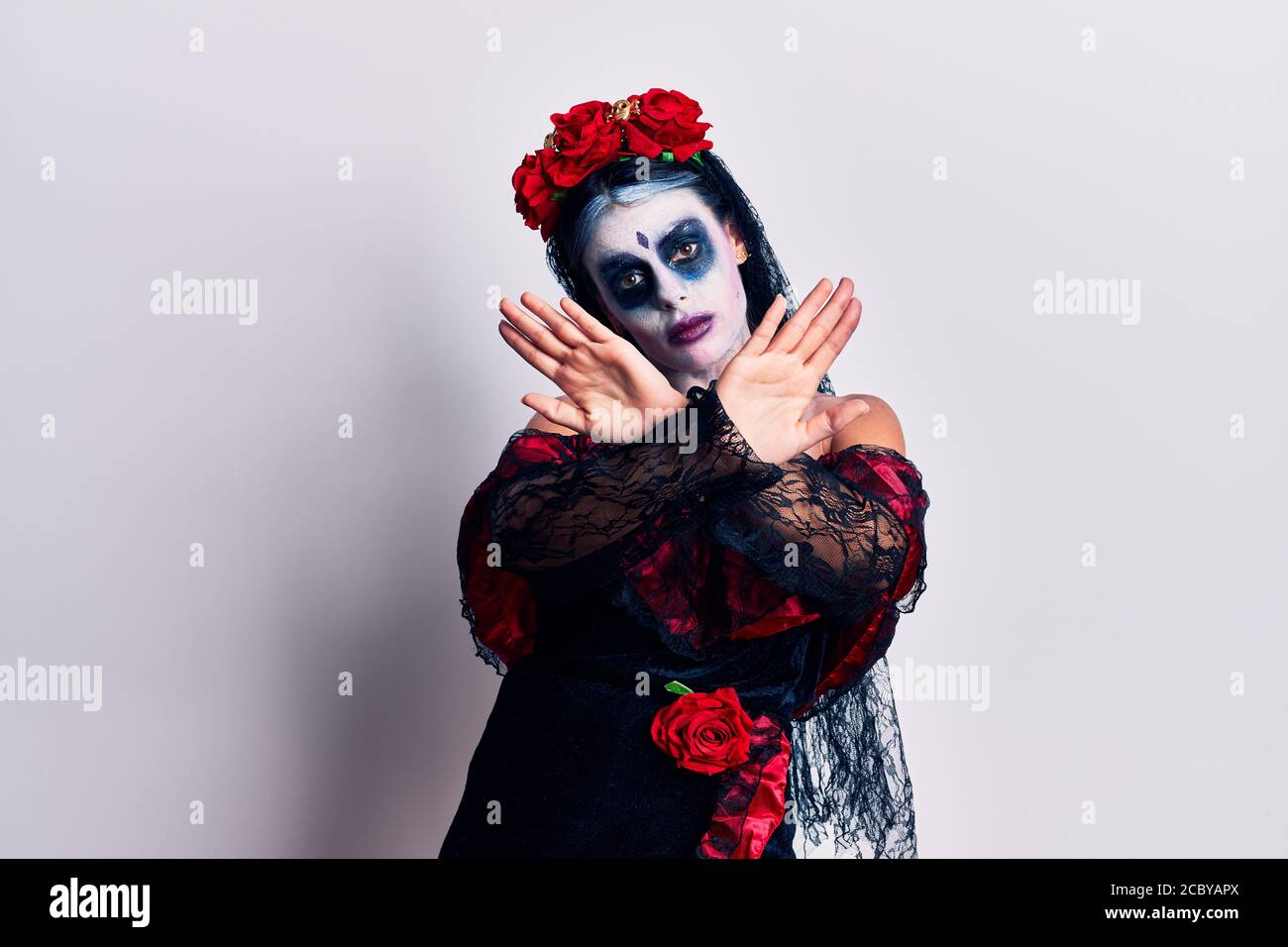 Young woman wearing mexican day of the dead makeup rejection expression ...