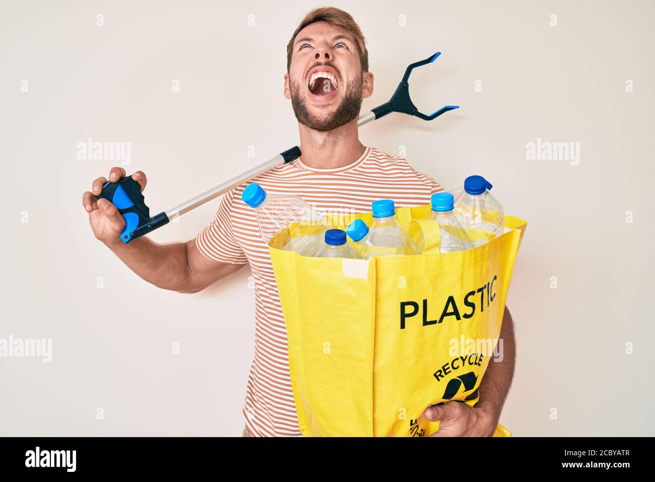 Young caucasian man holding recycling bag with plastic bottles and ...
