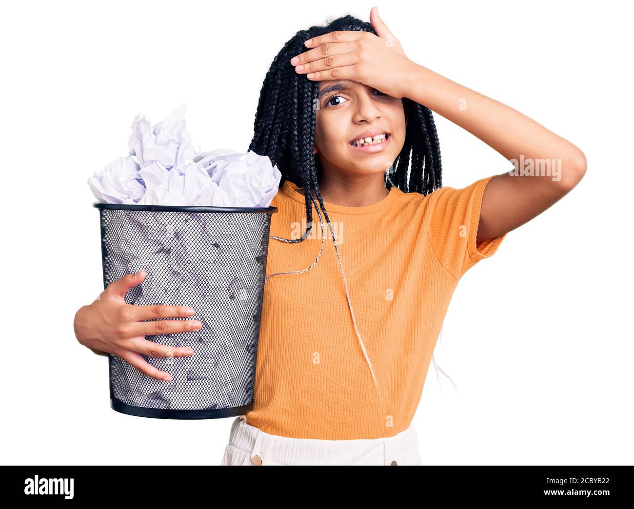 Cute african american girl holding paper bin full of crumpled papers ...