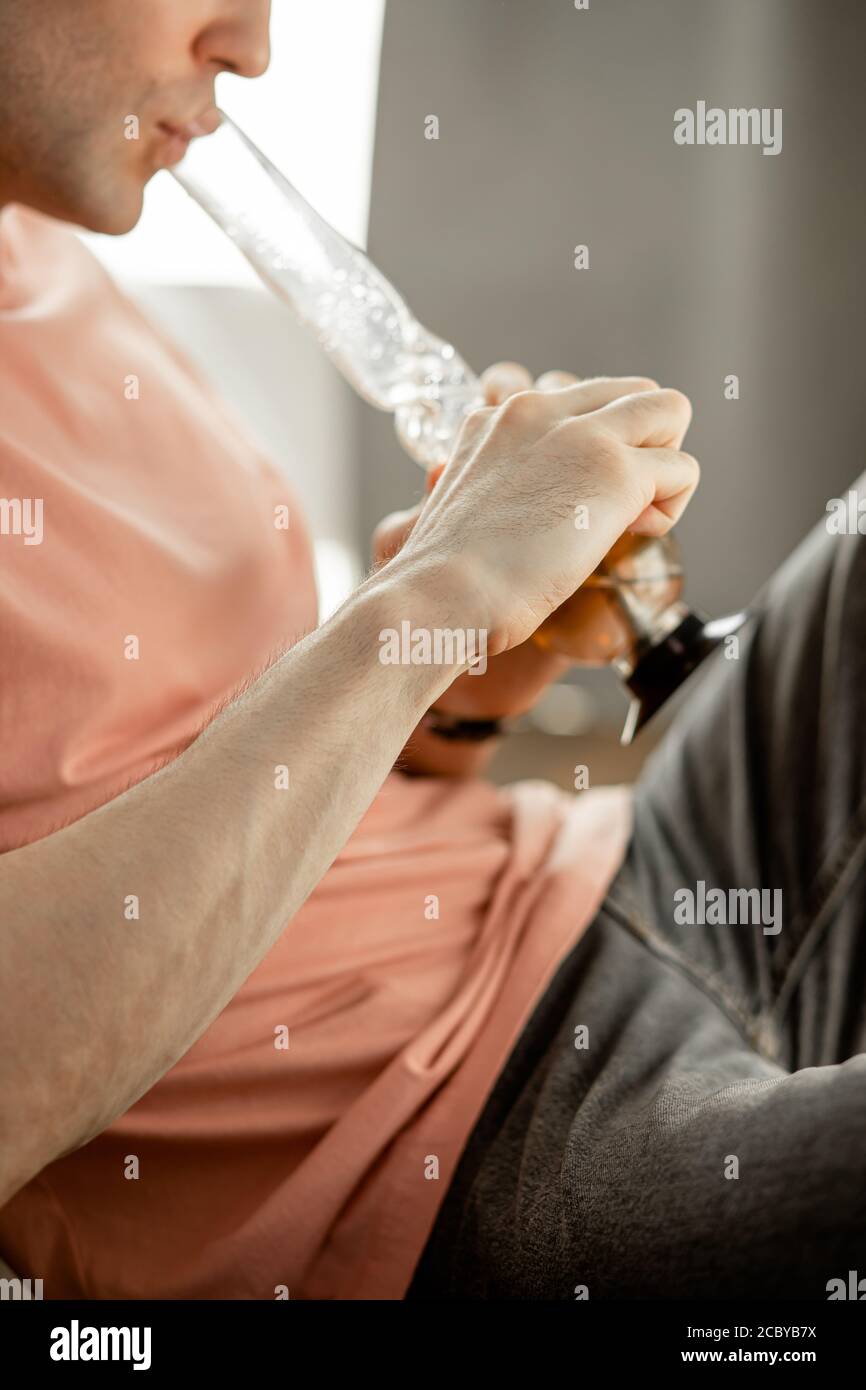 young man heats bong with a lighter. legalization of marijuana ...