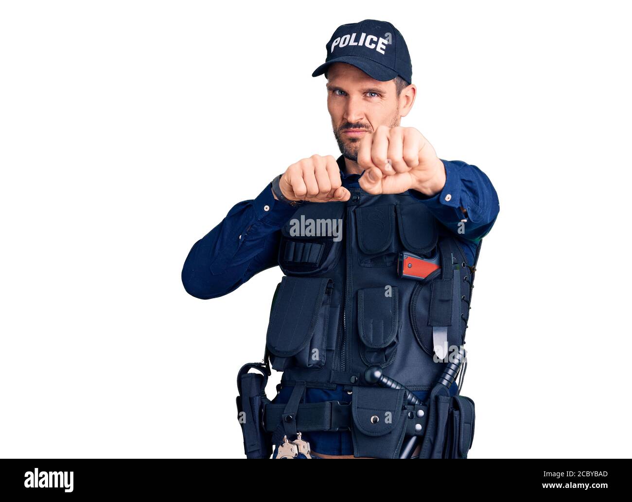 Young handsome man wearing police uniform punching fist to fight ...