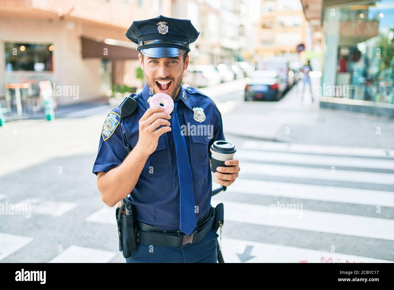 Young handsome hispanic policeman wearing police uniform smiling happy ...