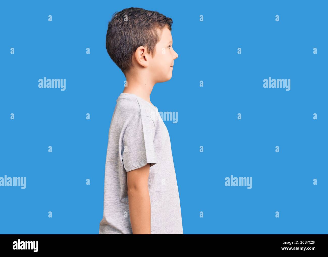 Cute blond kid wearing casual clothes looking to side, relax profile ...