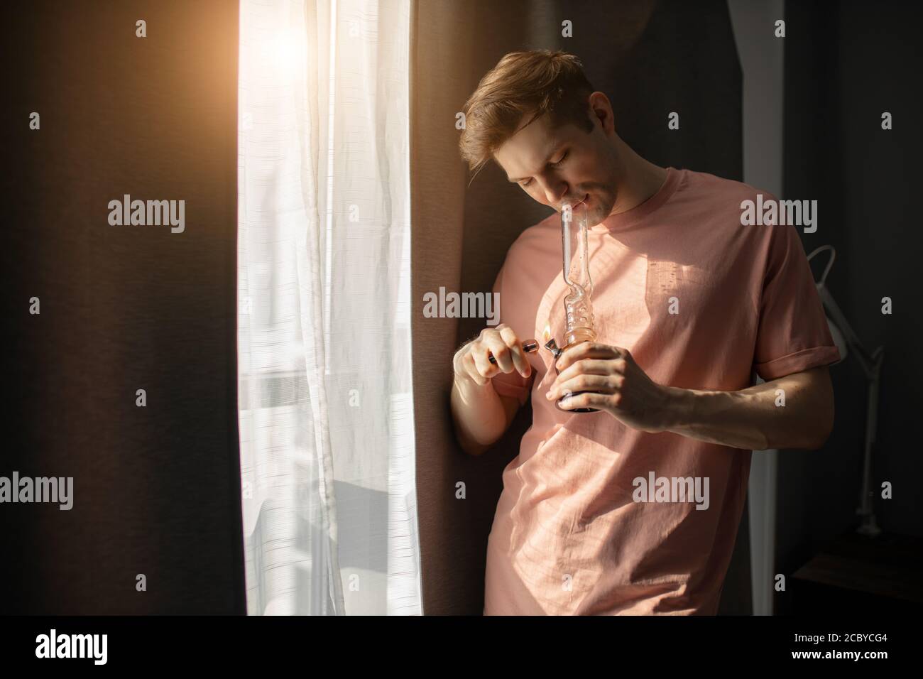 young caucasian man smokes cannabis, medican marijuana using Bong ...