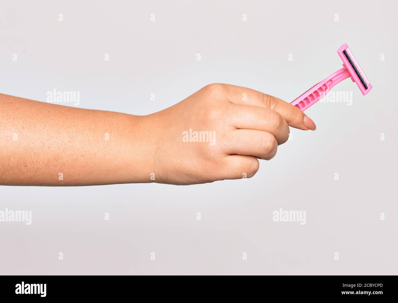 Hand of caucasian young woman holding pink razor over isolated white ...