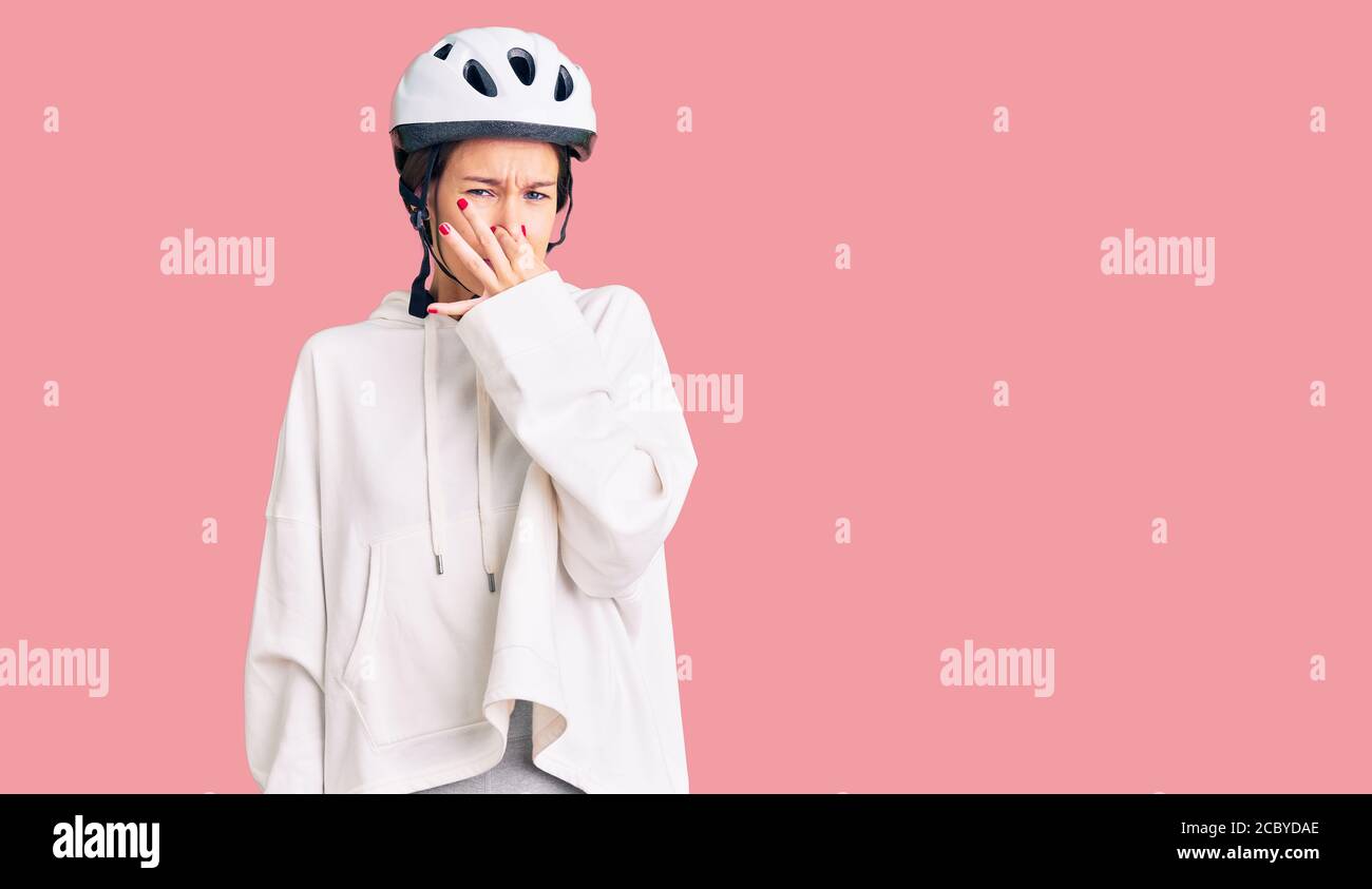 Beautiful brunette young woman wearing bike helmet and sporty clothes ...