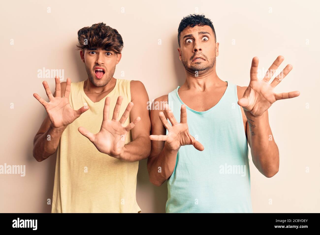 Young gay couple wearing casual clothes afraid and terrified with fear ...