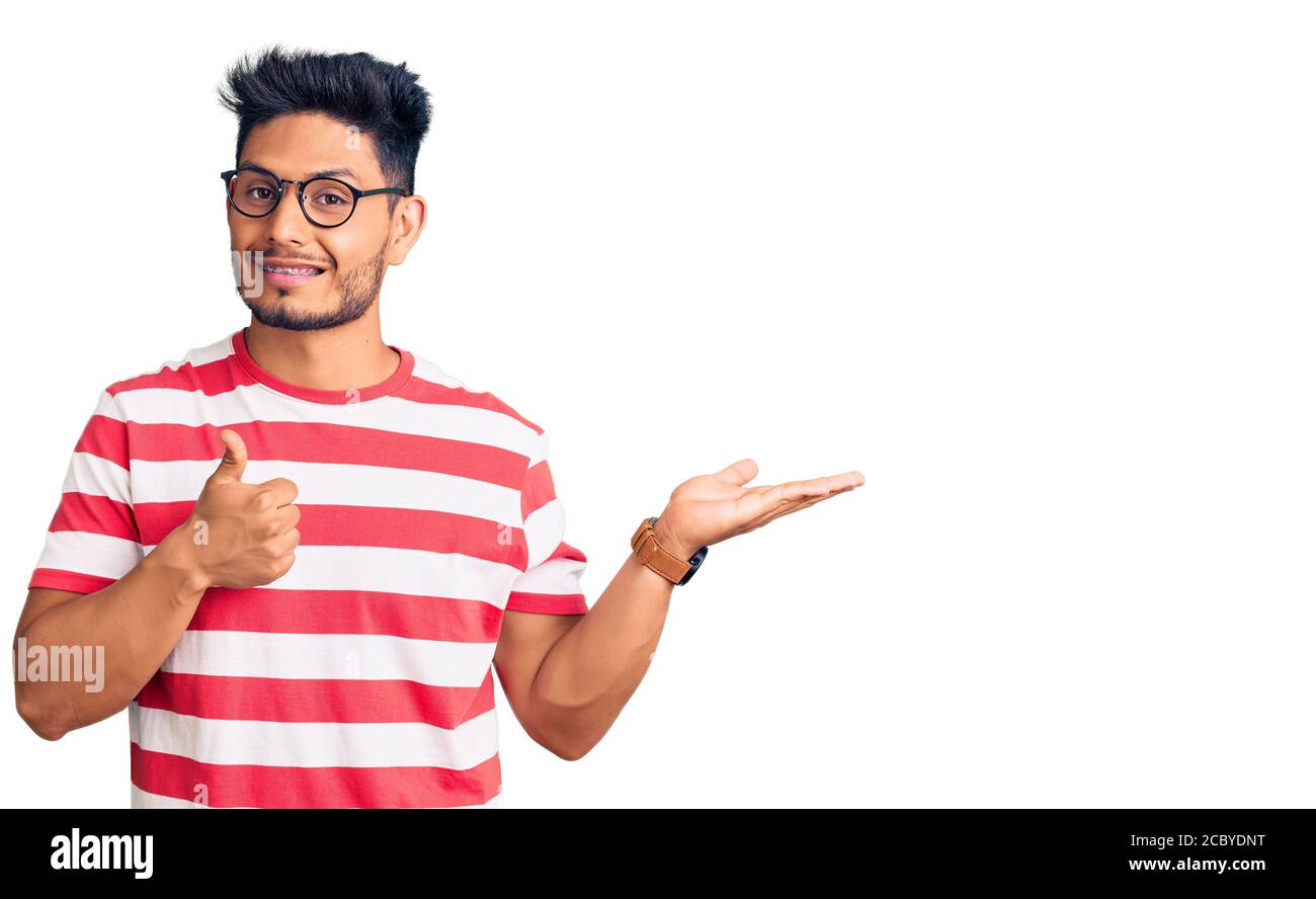 Handsome latin american young man wearing casual clothes and glasses ...