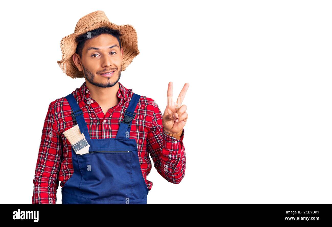 Handsome latin american young man weaing handyman uniform showing and ...