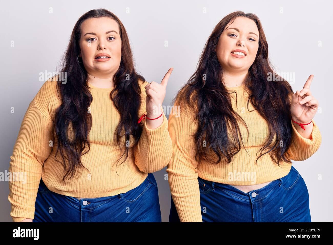 Young plus size twins wearing casual clothes pointing aside worried and ...