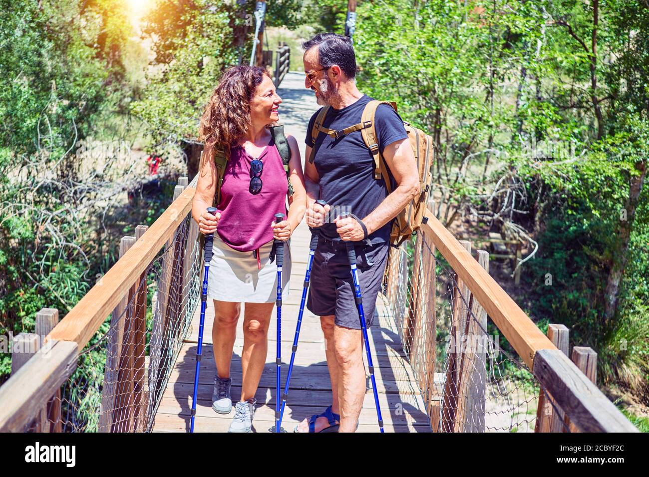 Beautiful couple of hiker wearing explorer clothes and backpack smiling ...