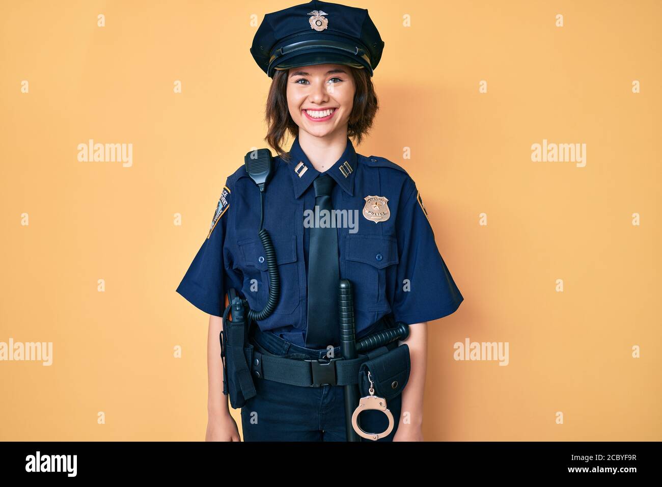 Young beautiful woman wearing police uniform with a happy and cool ...