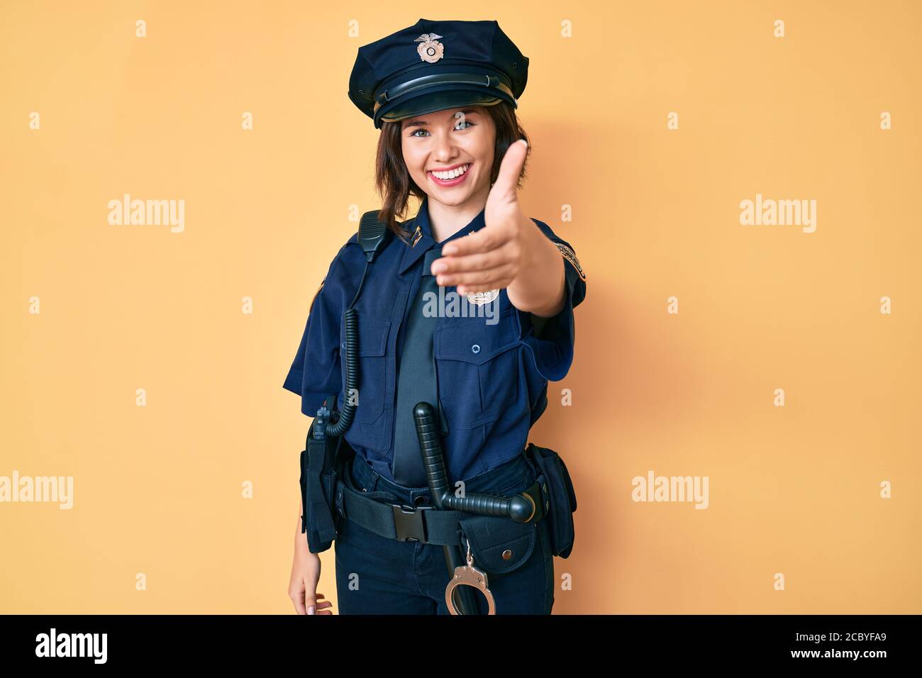 Young beautiful woman wearing police uniform smiling friendly offering ...