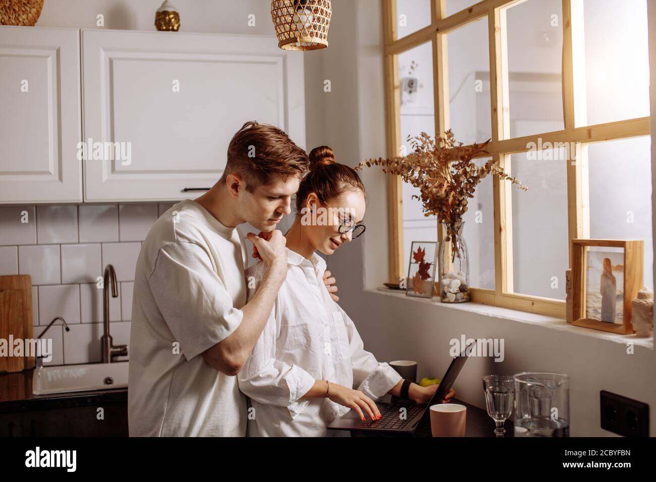 handsome caucasian man hugs her working wife, take care of her. woman ...