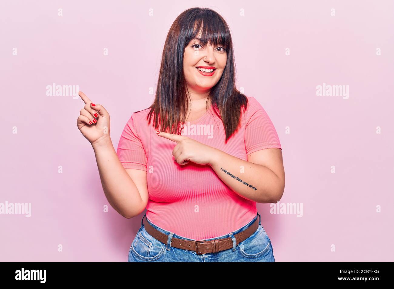 Young plus size woman wearing casual clothes smiling and looking at the ...