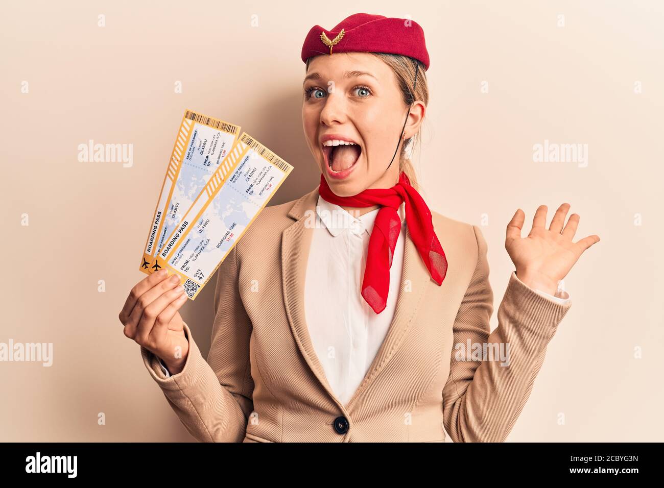 Young beautiful blonde girl wearing stewardess uniform holding boarding ...