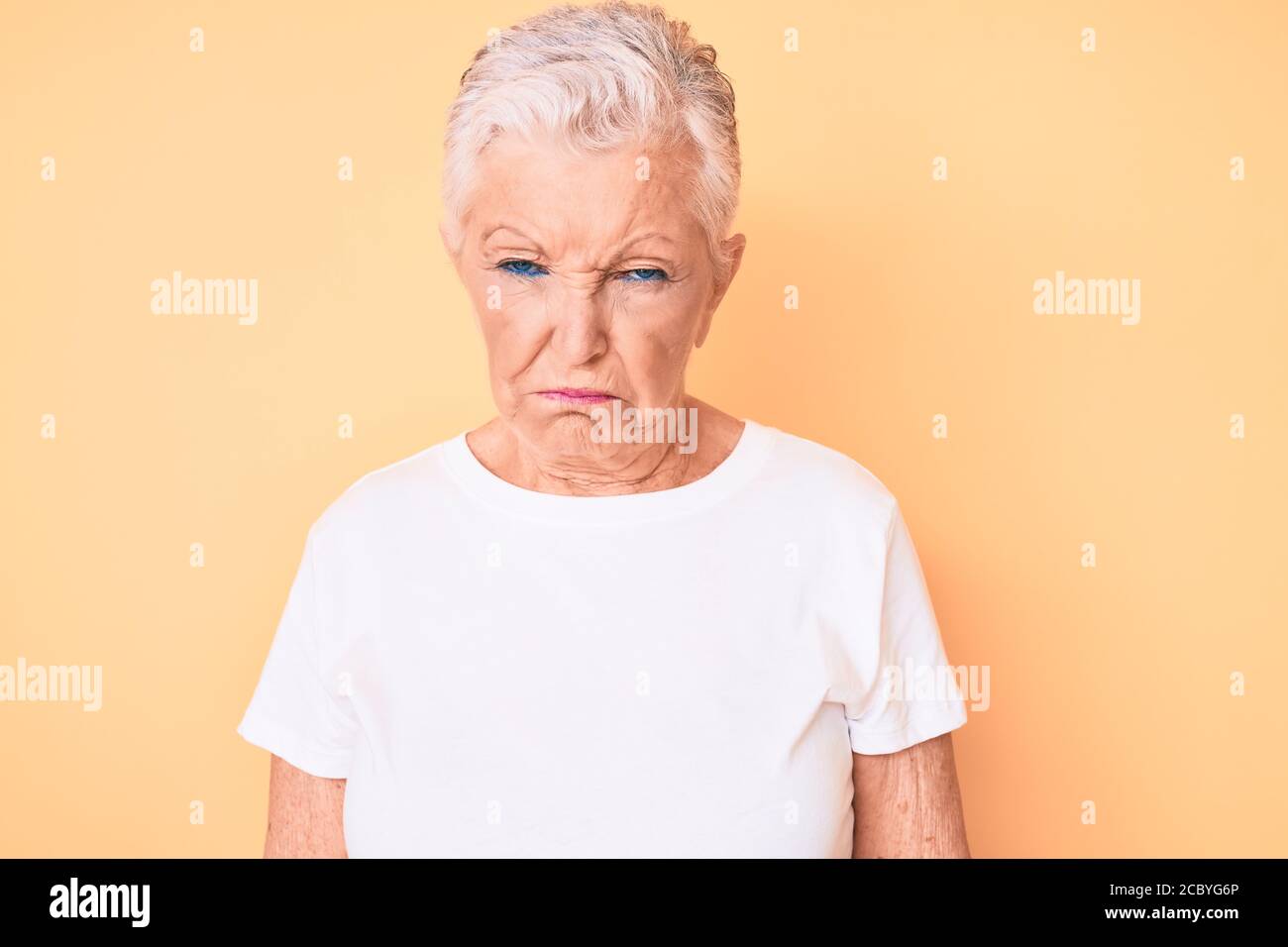 Senior beautiful woman with blue eyes and grey hair wearing classic ...