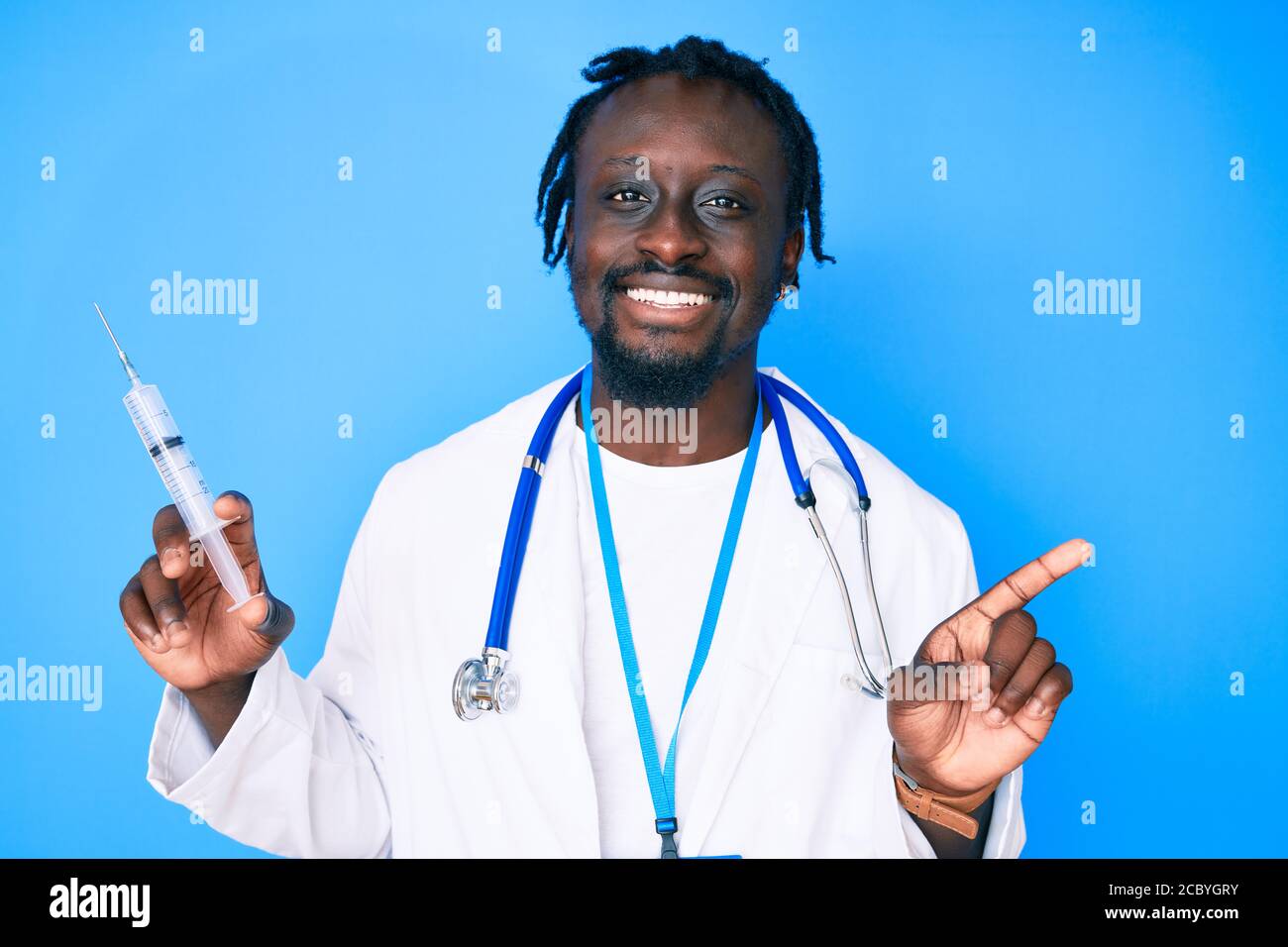 Young african american man with braids wearing doctor stethoscope holding syringe smiling happy ...