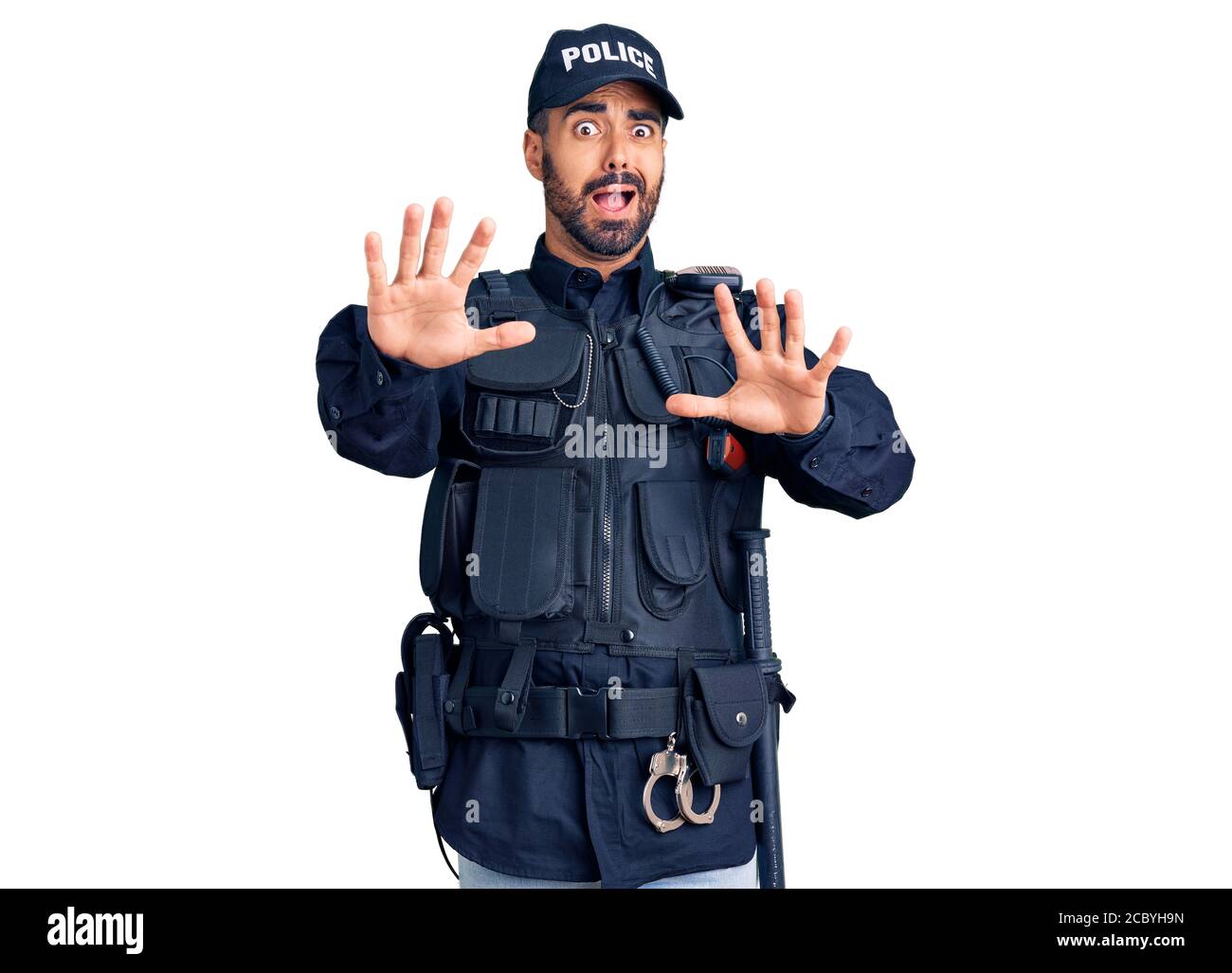 Young hispanic man wearing police uniform afraid and terrified with ...
