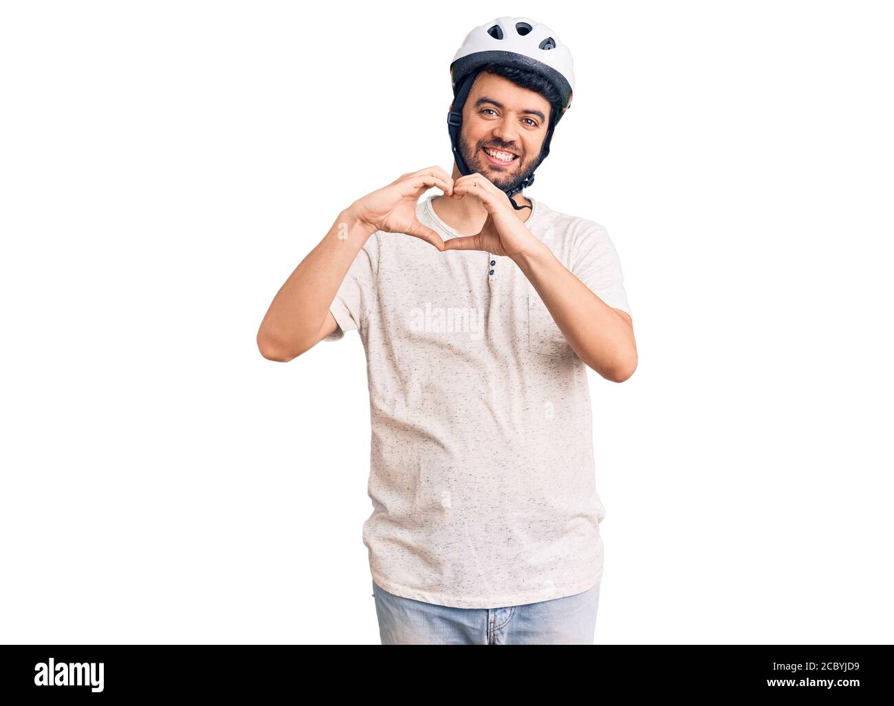 Young Hispanic Man Wearing Bike Helmet Smiling In Love Showing Heart
