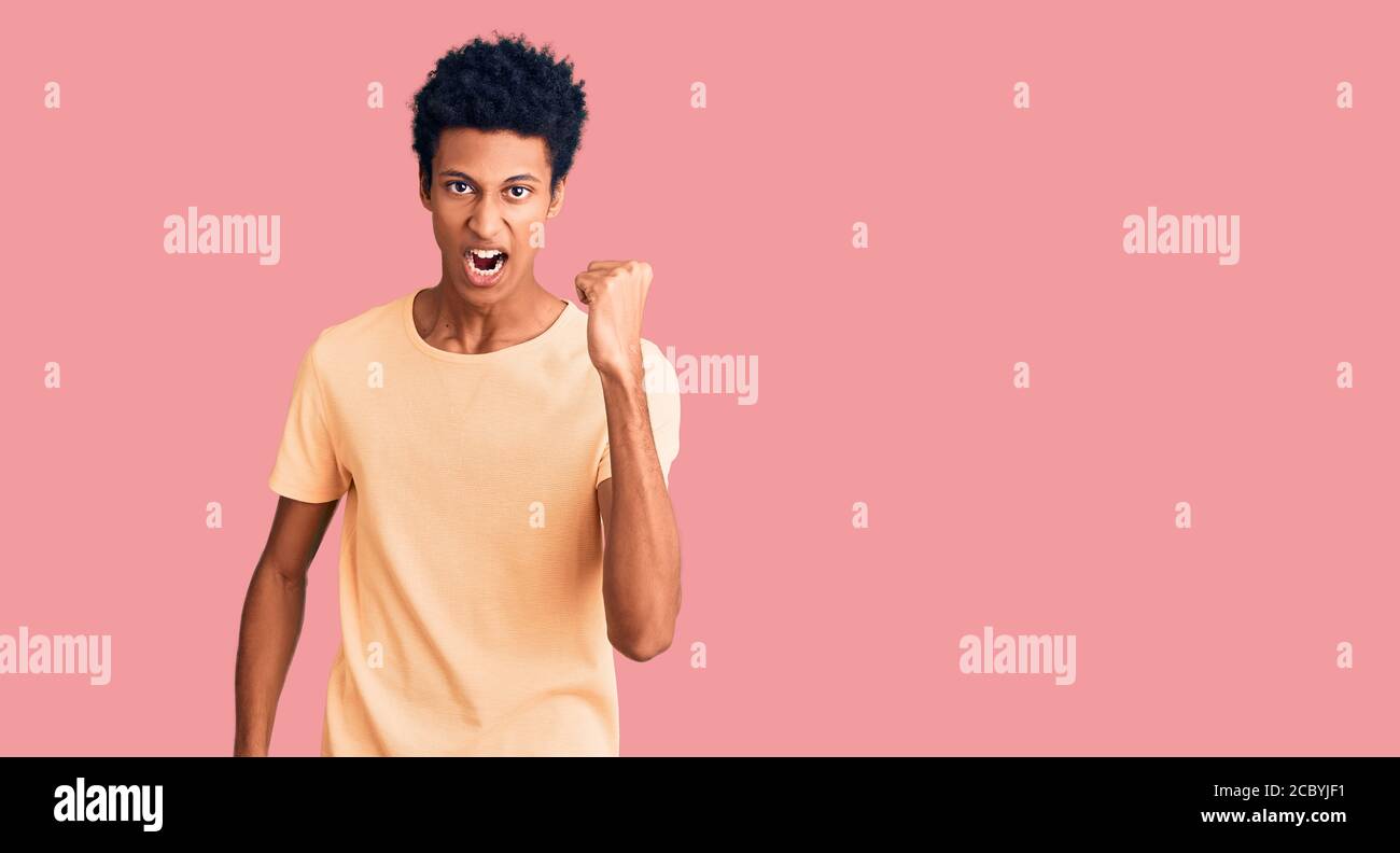 Young african american man wearing casual clothes angry and mad raising ...