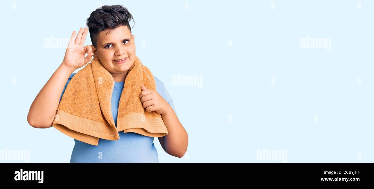 Little boy kid wearing sportswear and towel doing ok sign with fingers ...