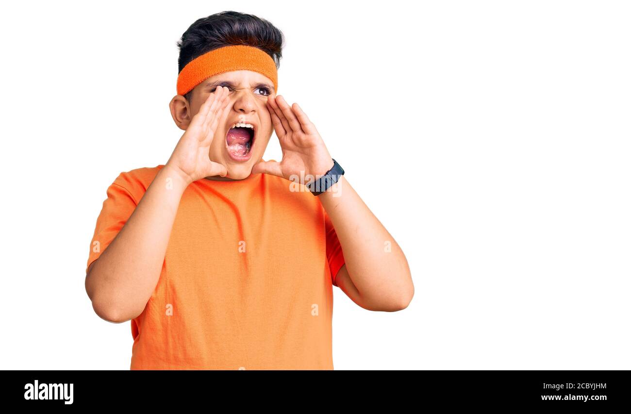 Little boy kid wearing sportswear shouting angry out loud with hands ...