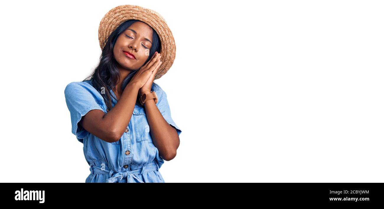 Young indian girl wearing summer hat sleeping tired dreaming and posing ...